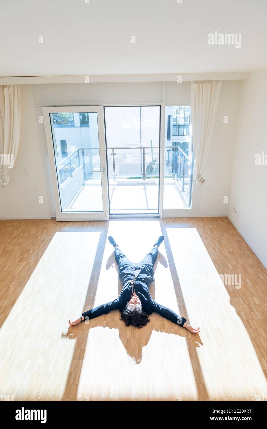 Woman Lying on the Floor in a Empty Room with Sunlight at Home in ...
