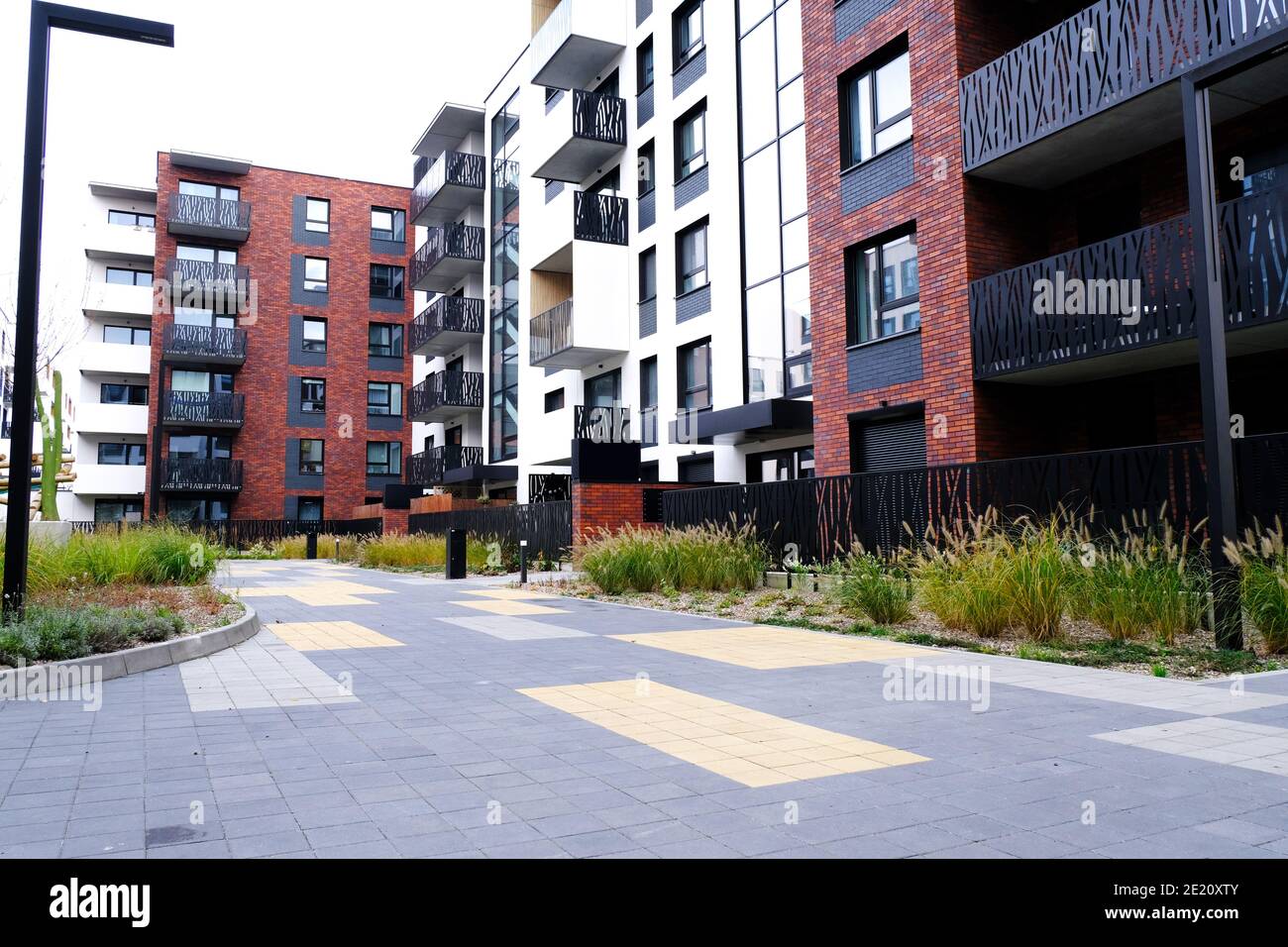 Courtyard of modern apartment buildings district with sidewalk and ...
