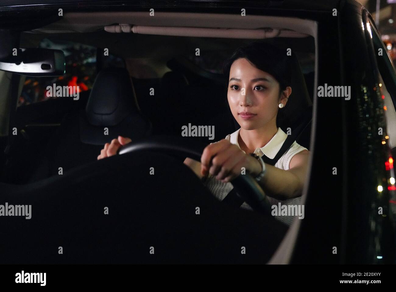 Driving at night young woman Stock Photo - Alamy