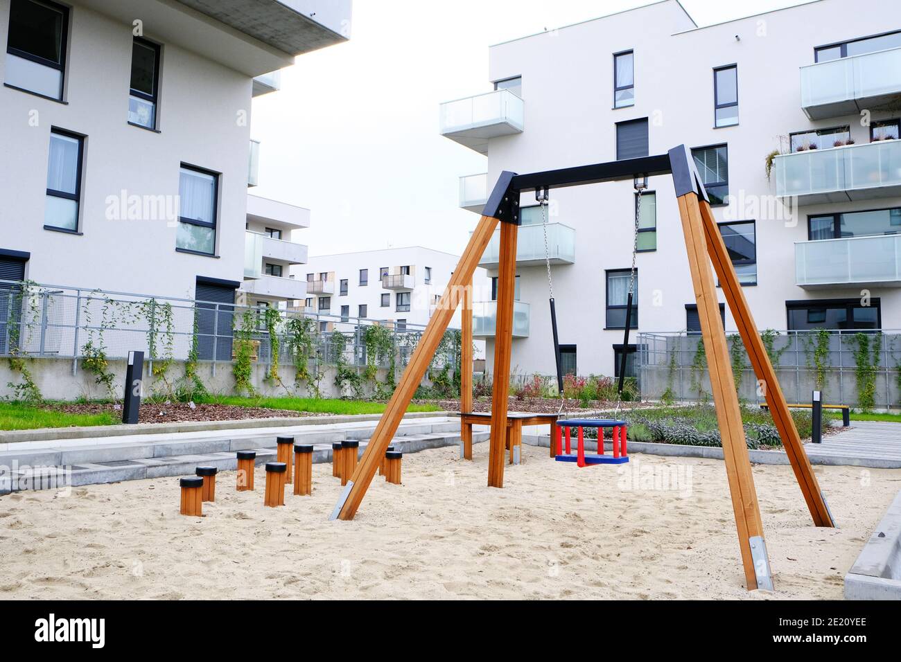 Playground with a children swing in a cozy courtyard of modern ...