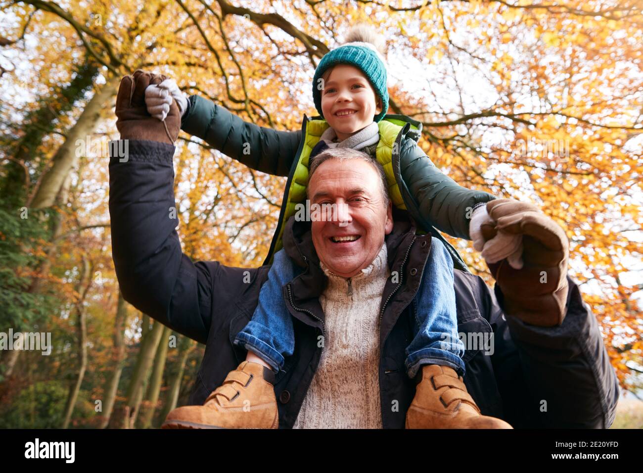 Portrait Of Grandfather Giving Grandson Ride On Shoulders As They Walk ...