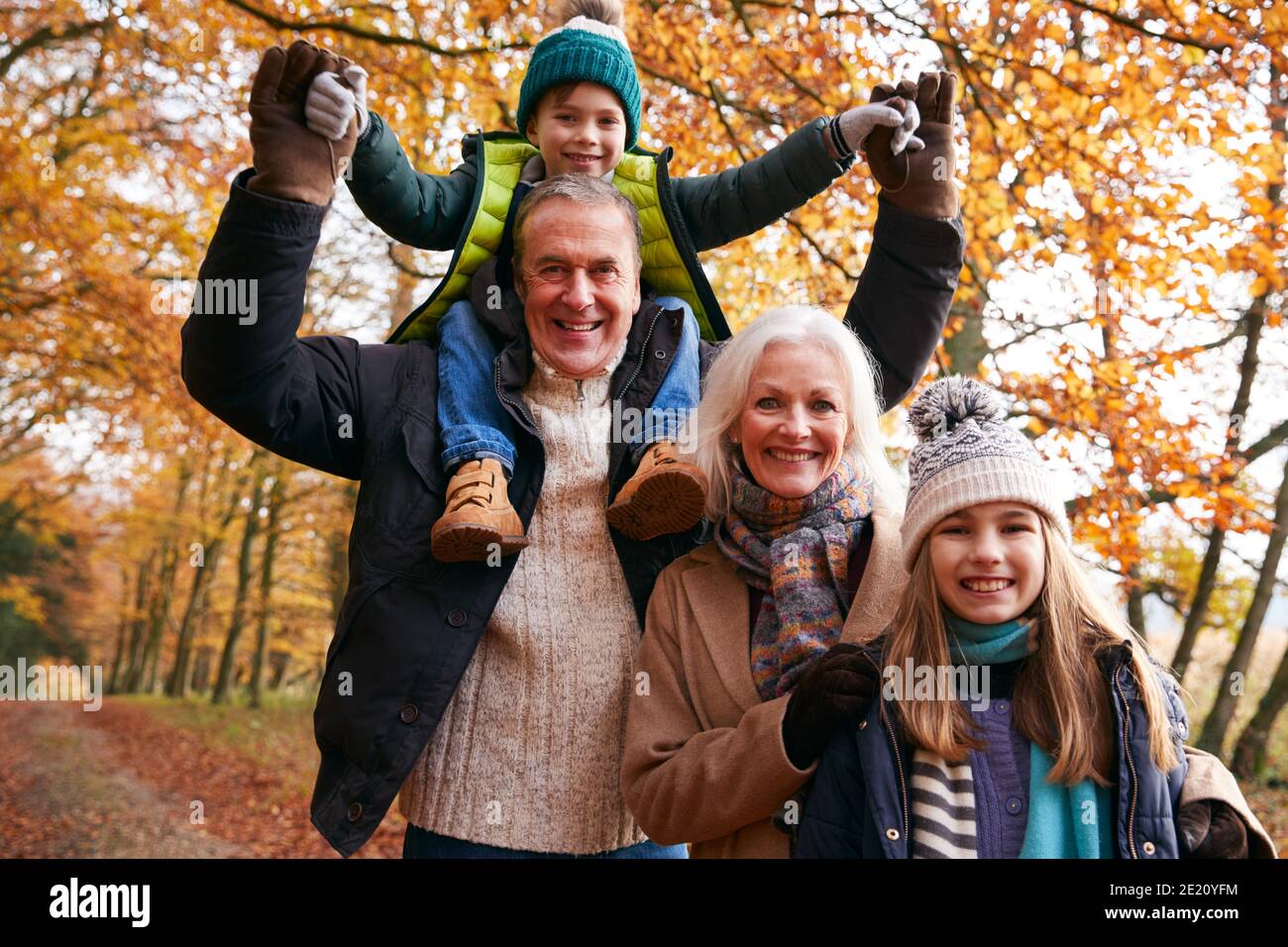 Portrait Of Grandparents With Grandchildren Enjoying Walk Along Autumn ...