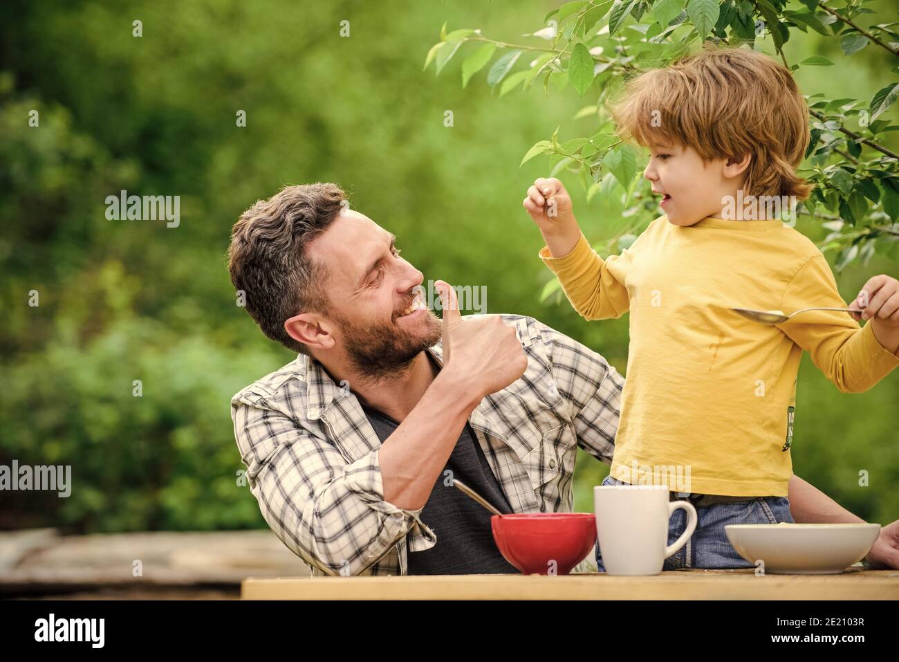 family dinner time. father and son eating outdoor. happy fathers day ...