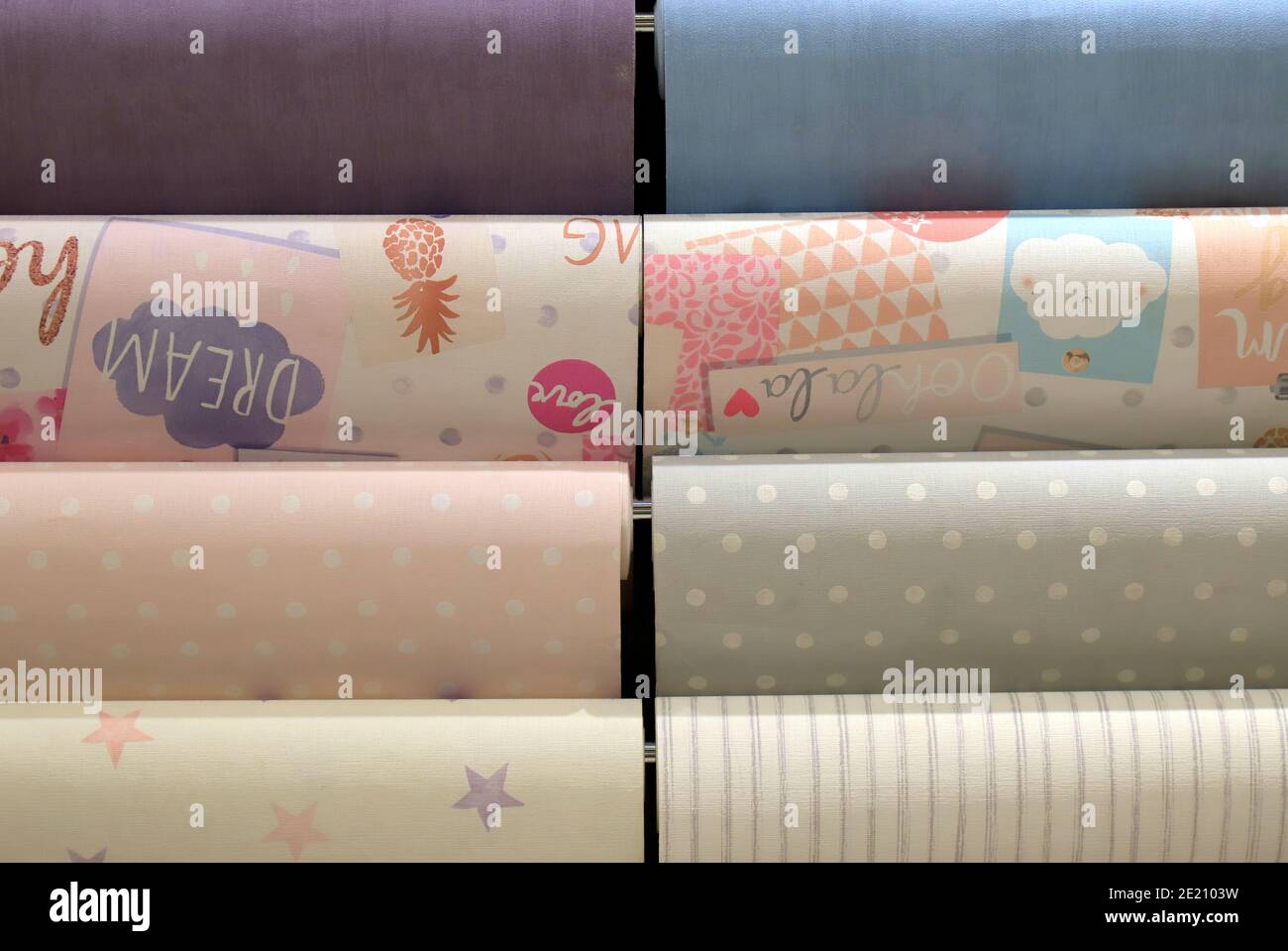 Rolled up rolls of vinyl wallpaper. Different textures and colors, as ...