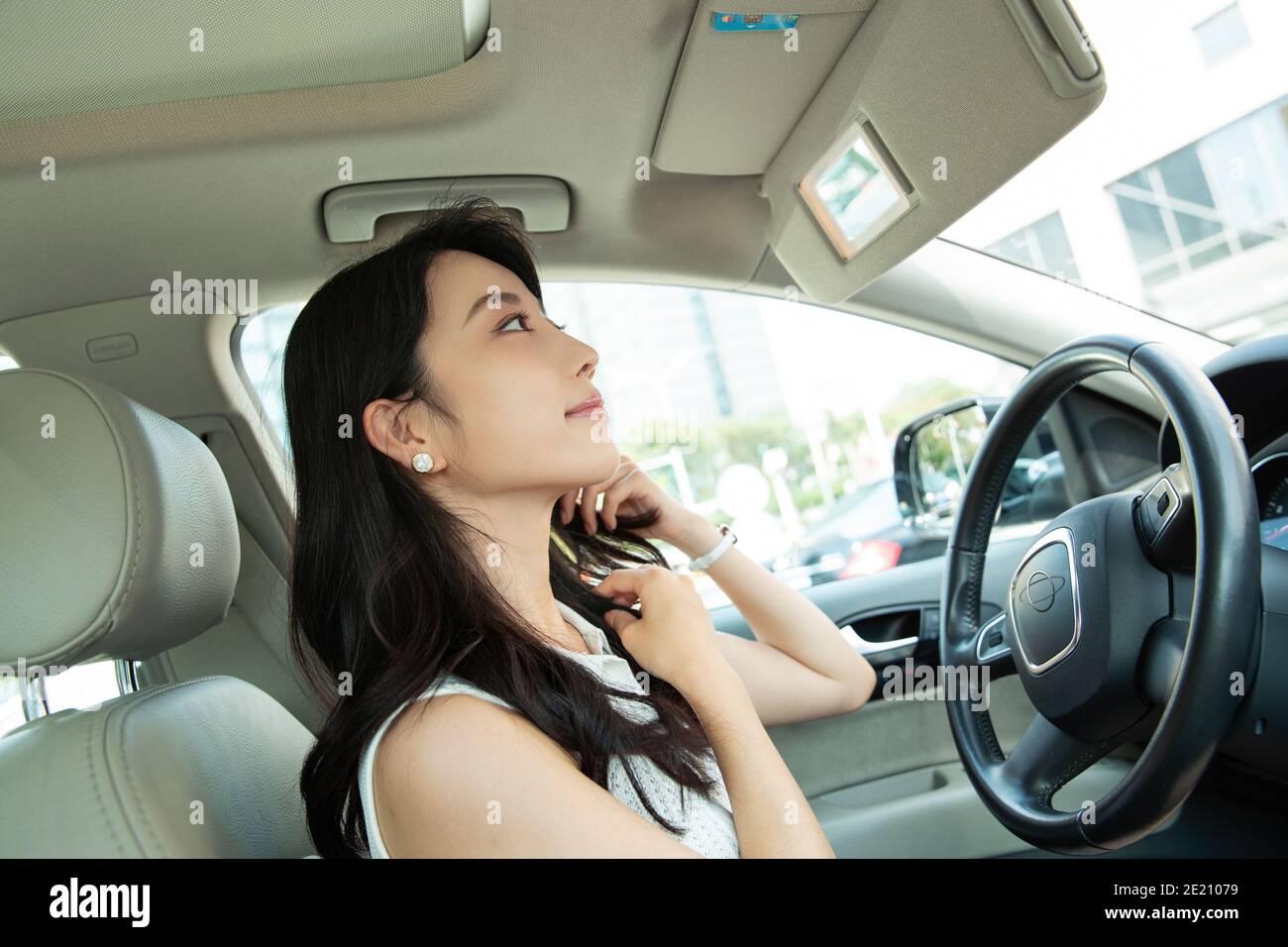 Young woman sitting in the car, look in the mirror Stock Photo - Alamy