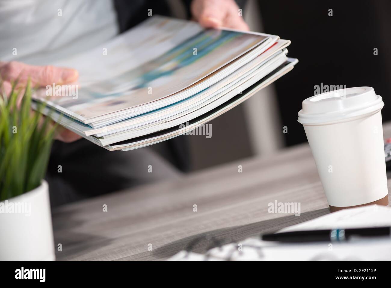Male hands holding a stack of magazines Stock Photo - Alamy