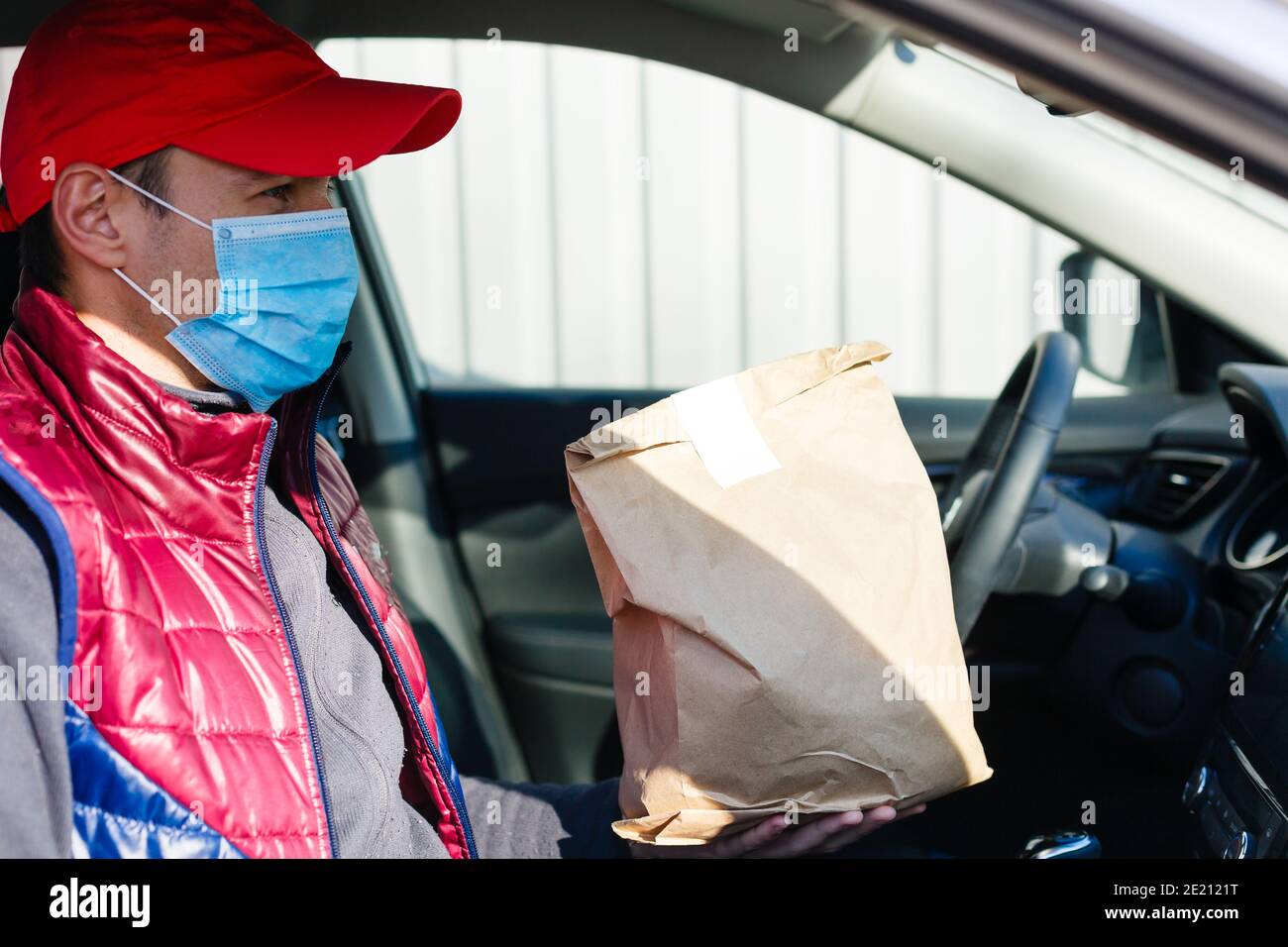 delivery man delivers orders by car. Delivery service under quarantine ...