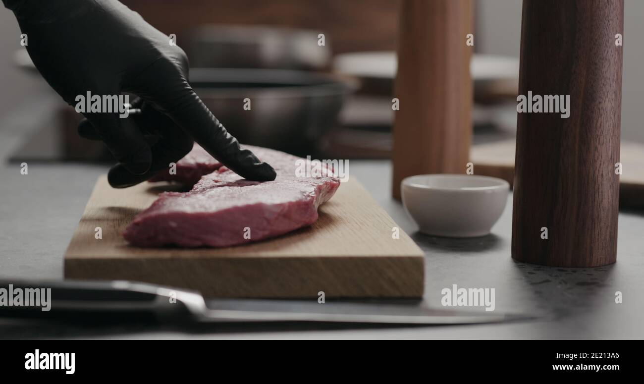 man cut raw beef steak on oak board, wide photo Stock Photo - Alamy