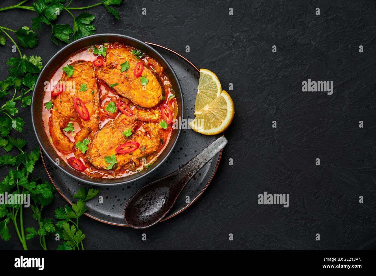 Macher Jhol in black bowl on dark slate table top. Indian cuisine ...