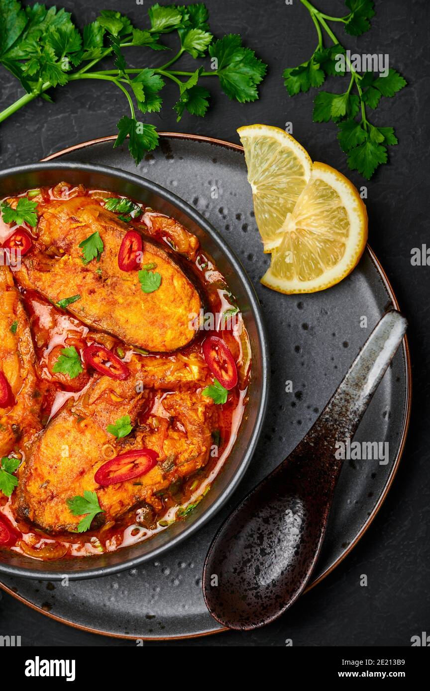 Macher Jhol in black bowl on dark slate table top. Indian cuisine ...