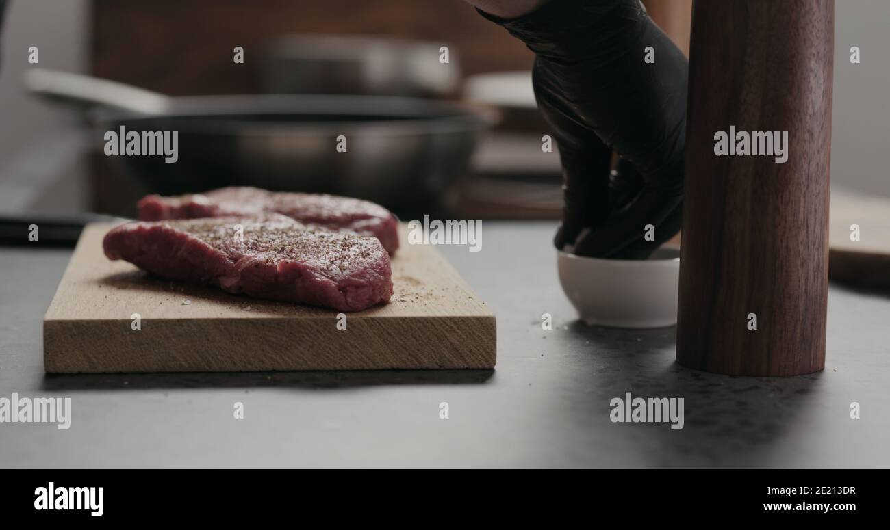 man salting raw beef steak on oak board, wide photo Stock Photo - Alamy