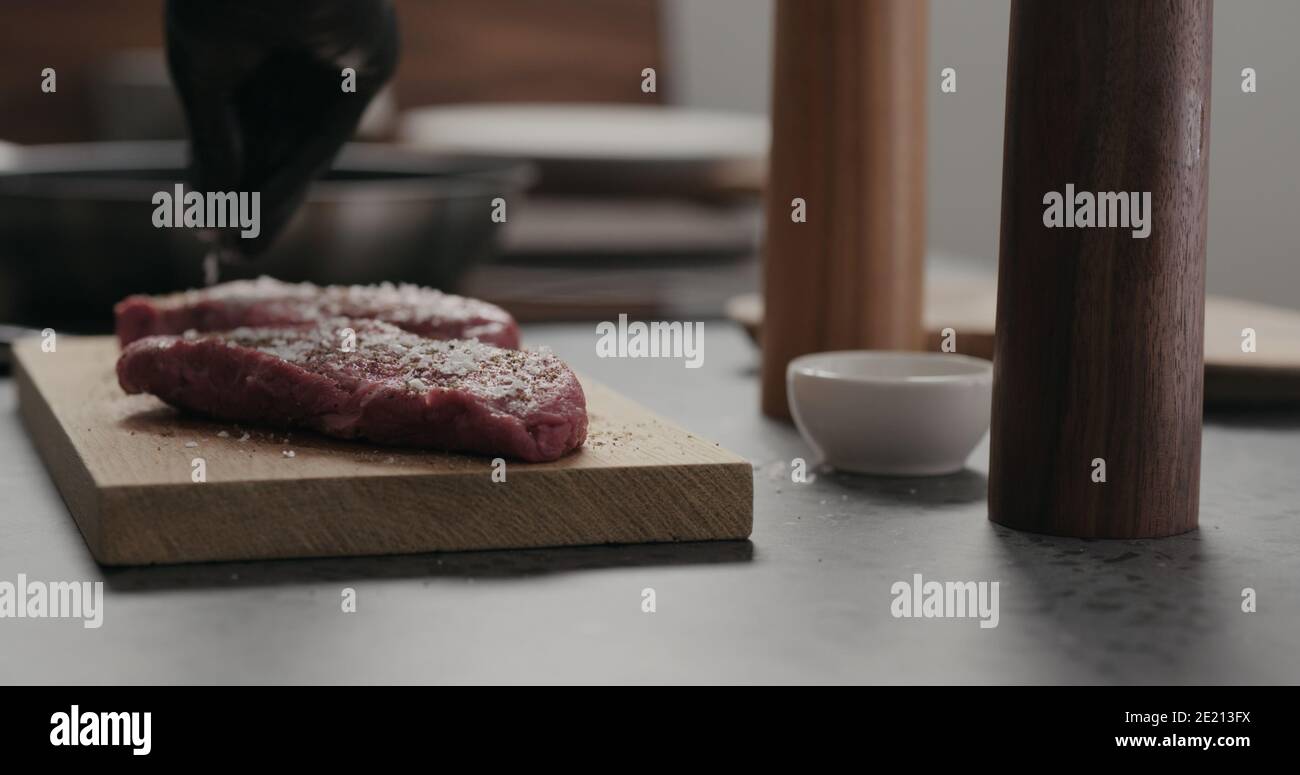 man salting raw beef steak on oak board, wide photo Stock Photo - Alamy