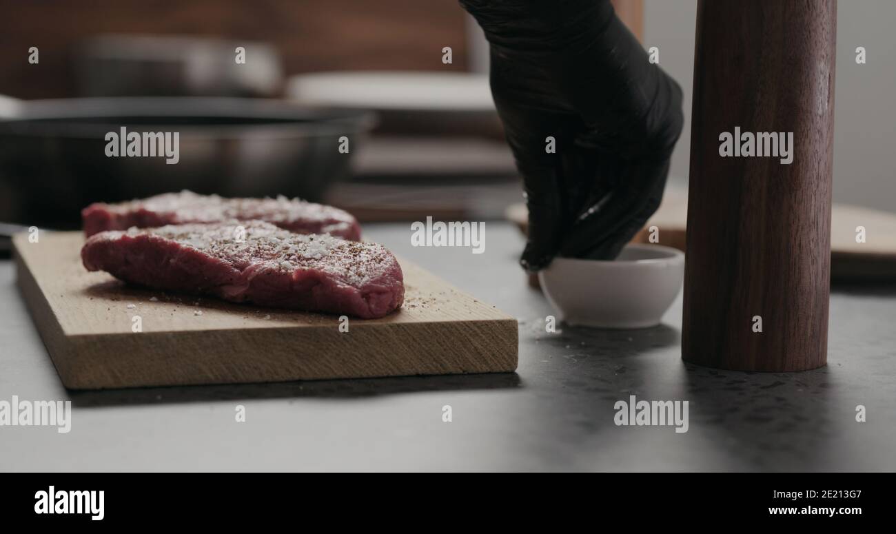 man salting raw beef steak on oak board, wide photo Stock Photo - Alamy