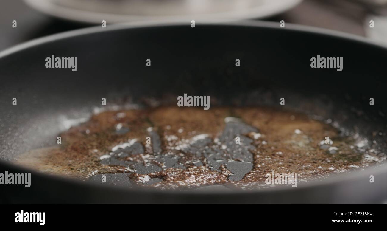 fat boiling on nonstick pan, wide photo Stock Photo - Alamy