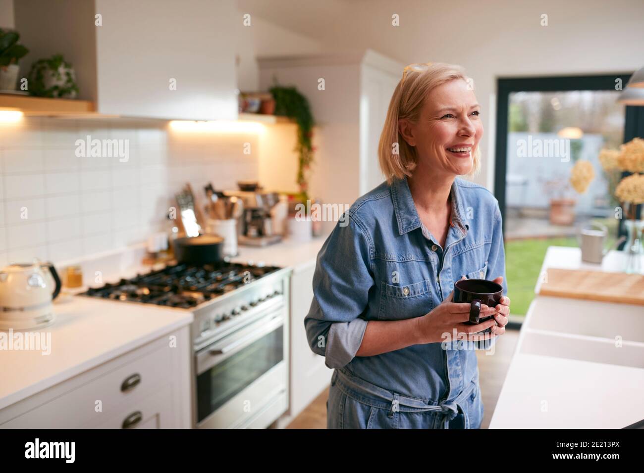 Mature woman laughing in kitchen hi-res stock photography and images ...