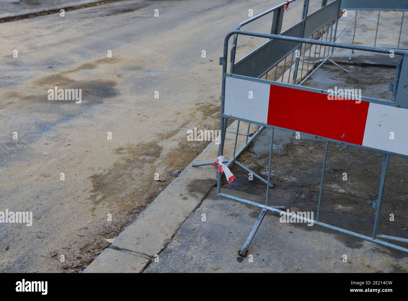 Steel fence around the excavation in the asphalt road. Building barrier ...