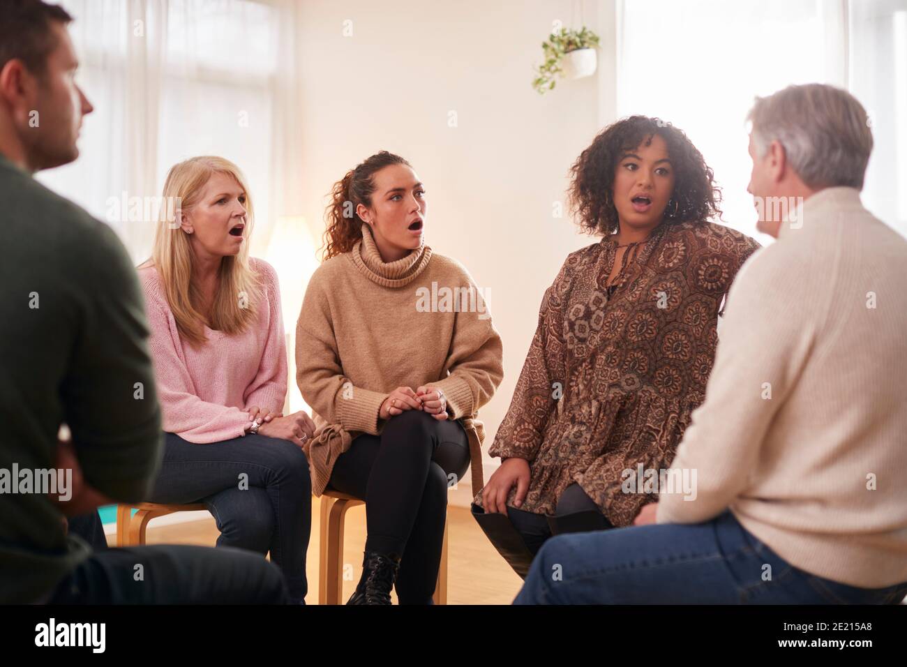 Shocked Group Consoling Man Speaking At Support Group Meeting For ...