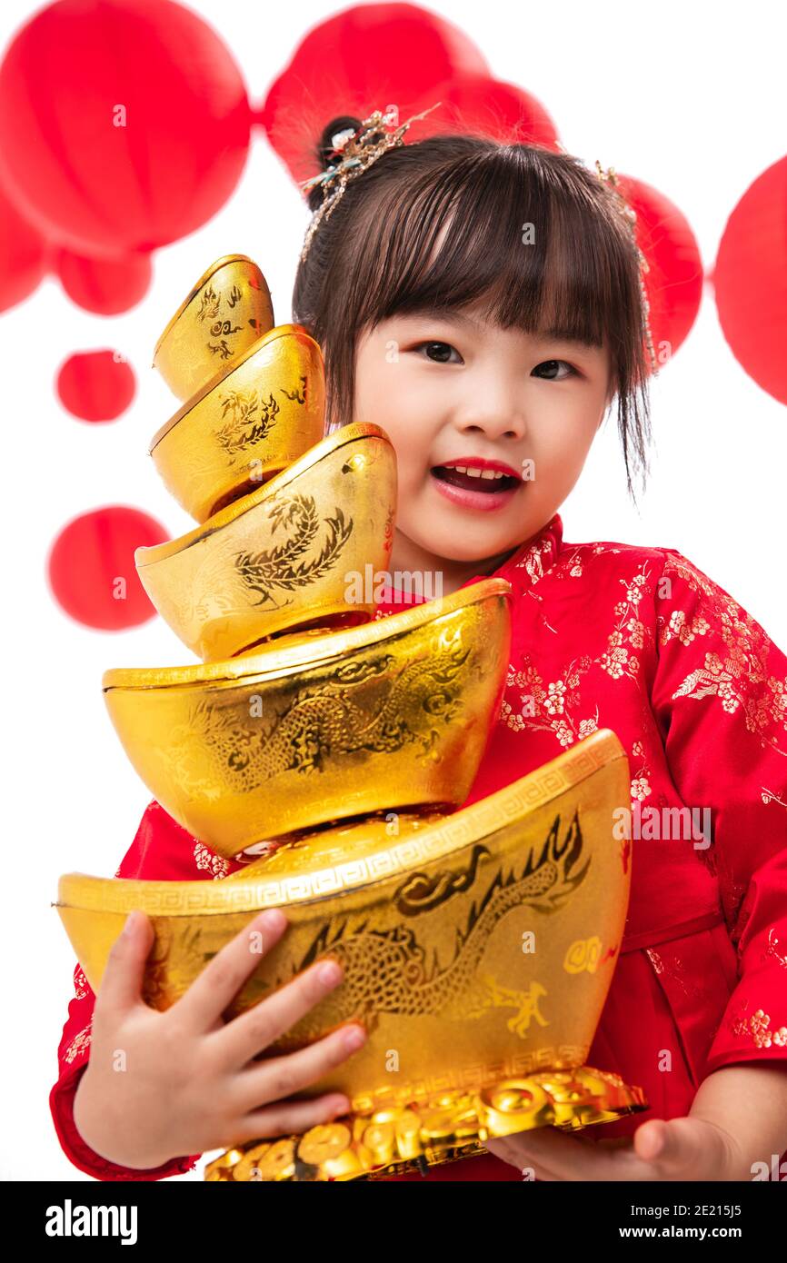 Lovely little girl holding the gold ingot Stock Photo - Alamy