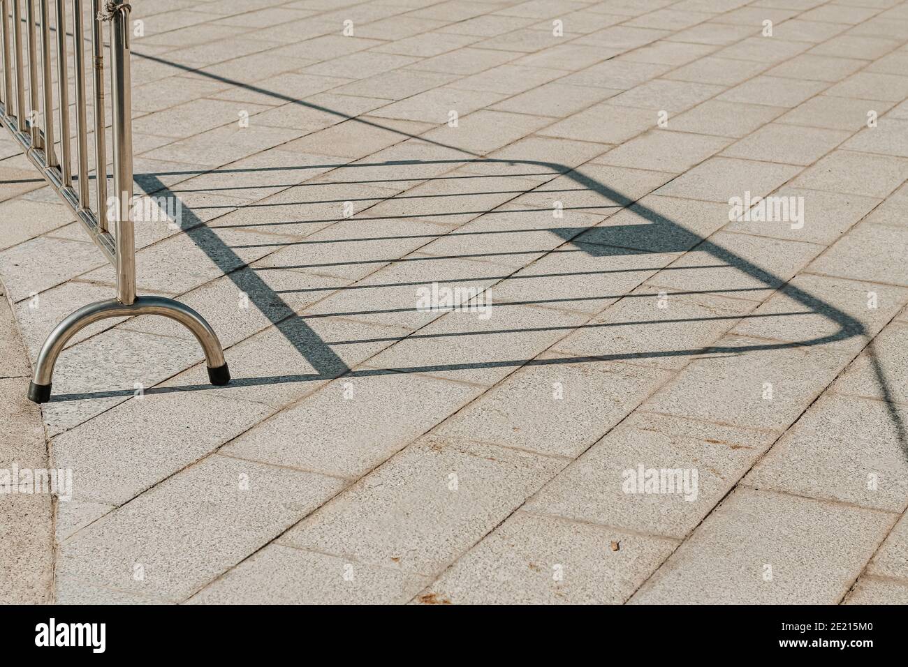 Closeup of the shadow of metal road bar projected on a brick pavement ...