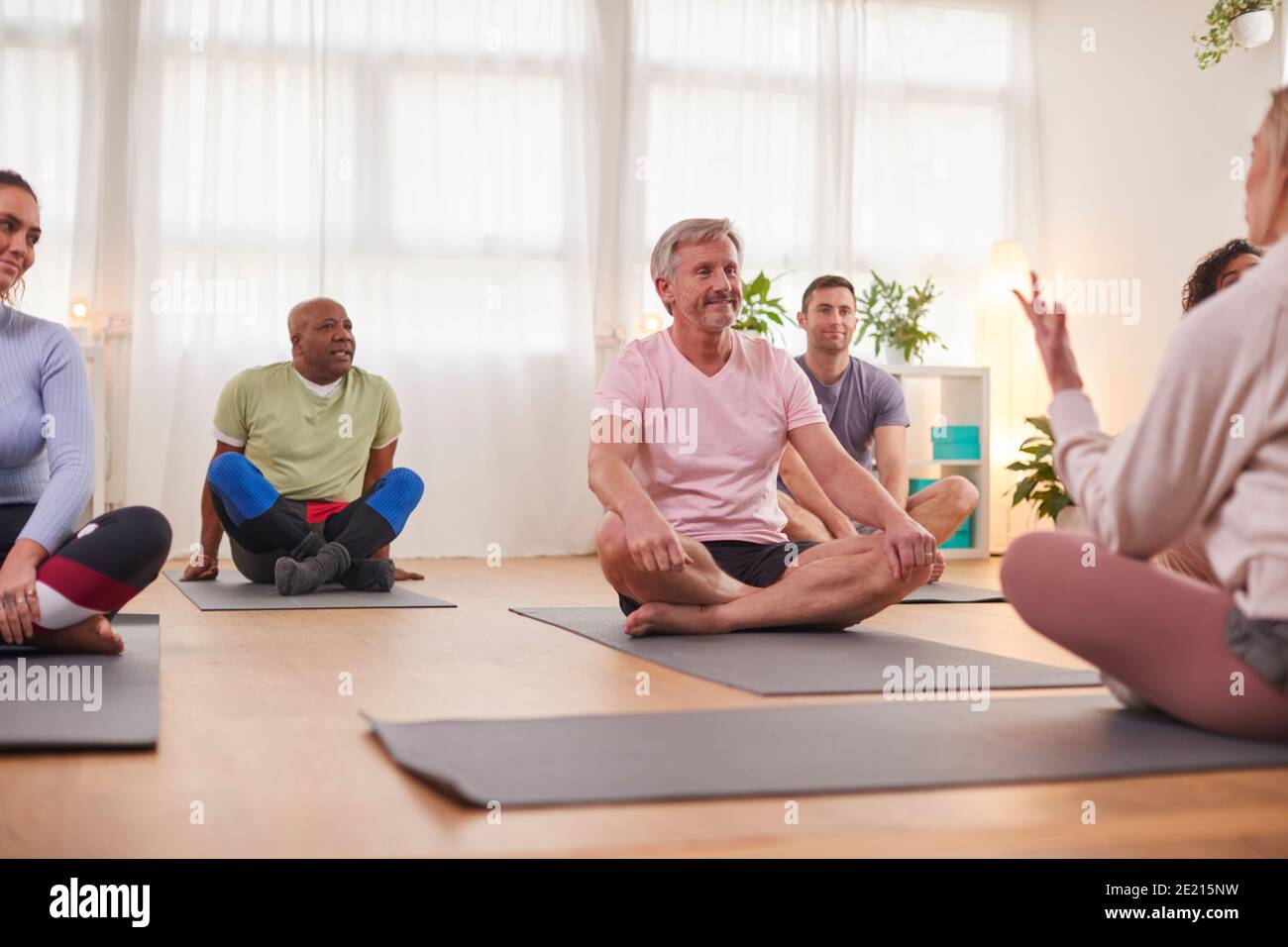 Group Of People Sitting On Exercise Mats Meeting For Fitness Or Yoga ...