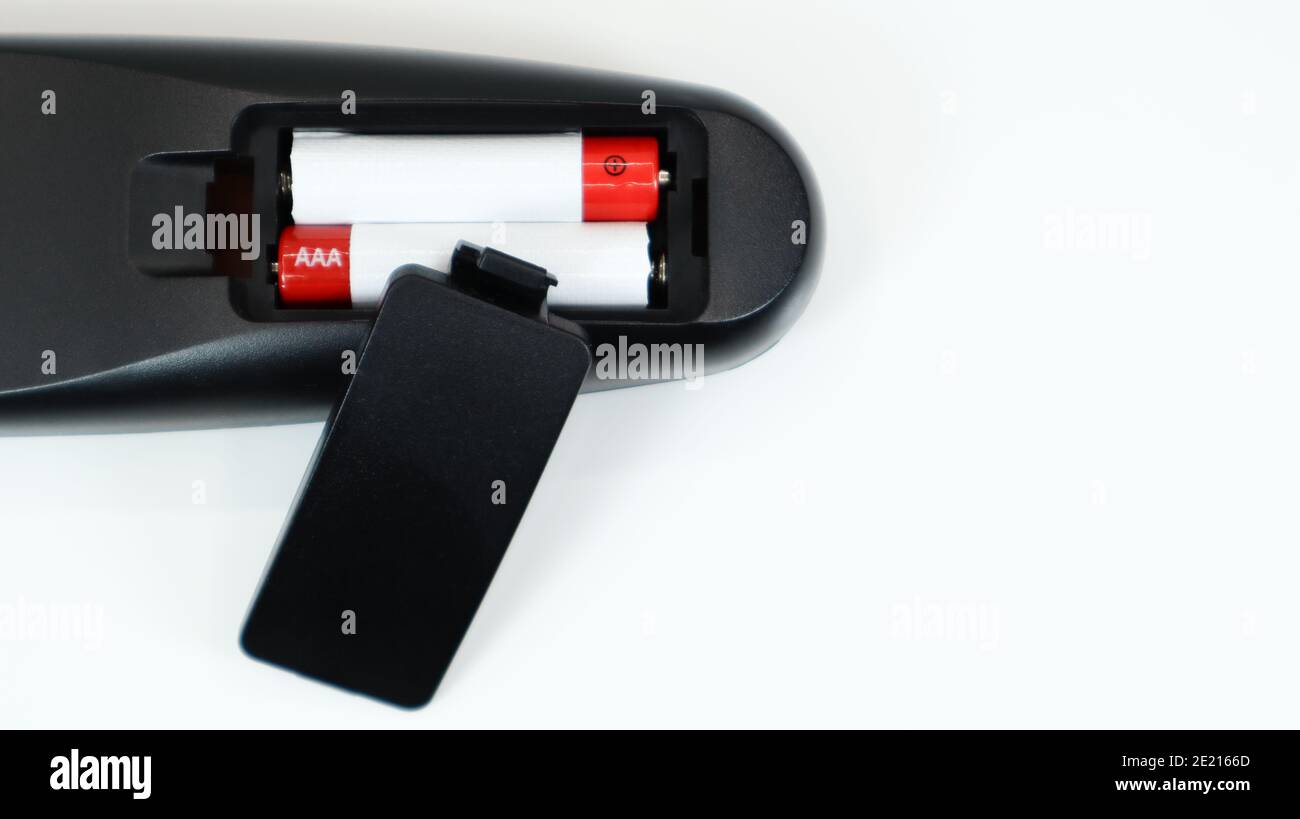 Black TV remote control with AAA alkaline batteries in red and white on ...