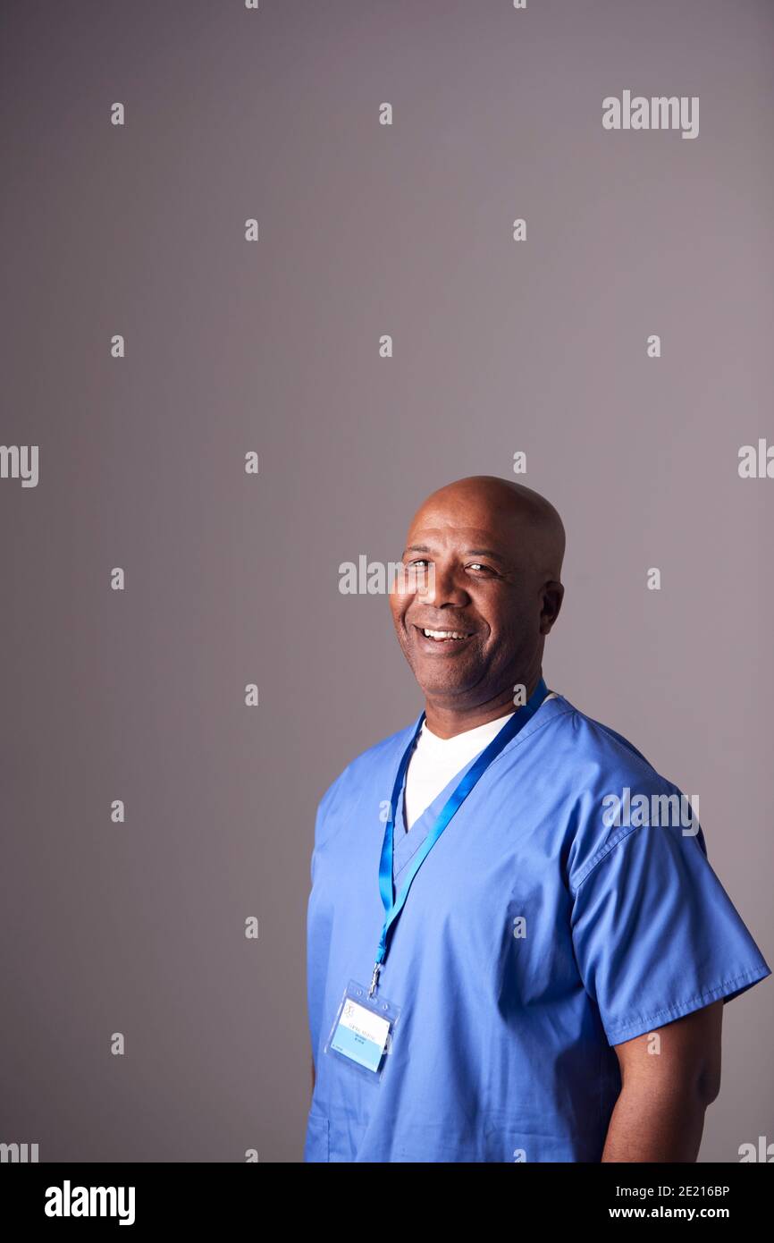 Studio Portrait Of Male Nurse Wearing Scrubs Standing Against Grey ...