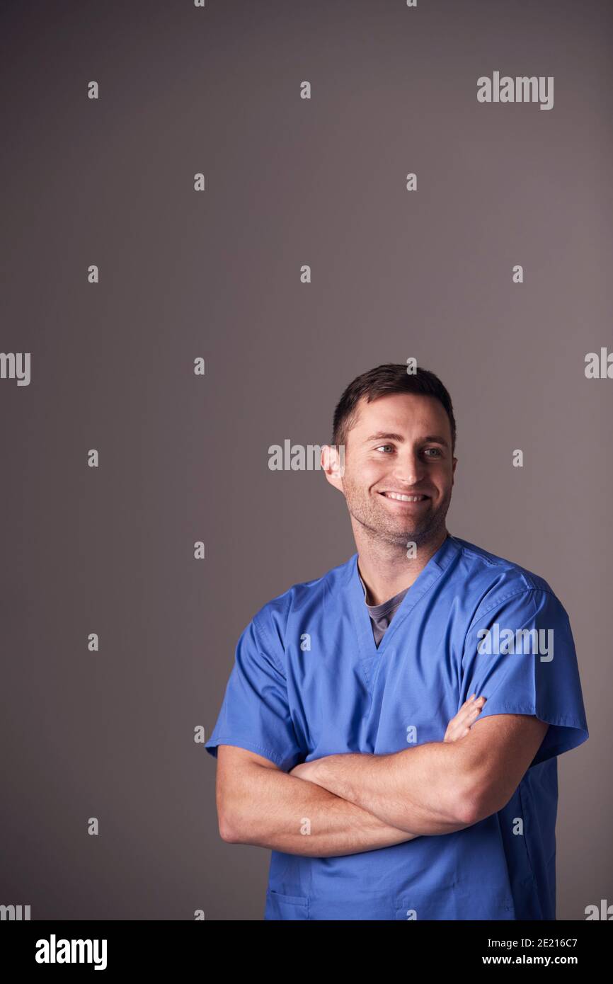 Studio Portrait Of Male Nurse Wearing Scrubs Standing Against Grey ...