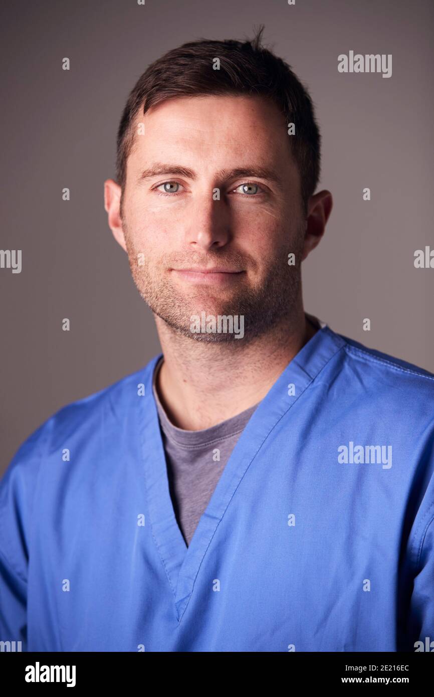 Studio Portrait Of Male Nurse Wearing Scrubs Standing Against Grey ...
