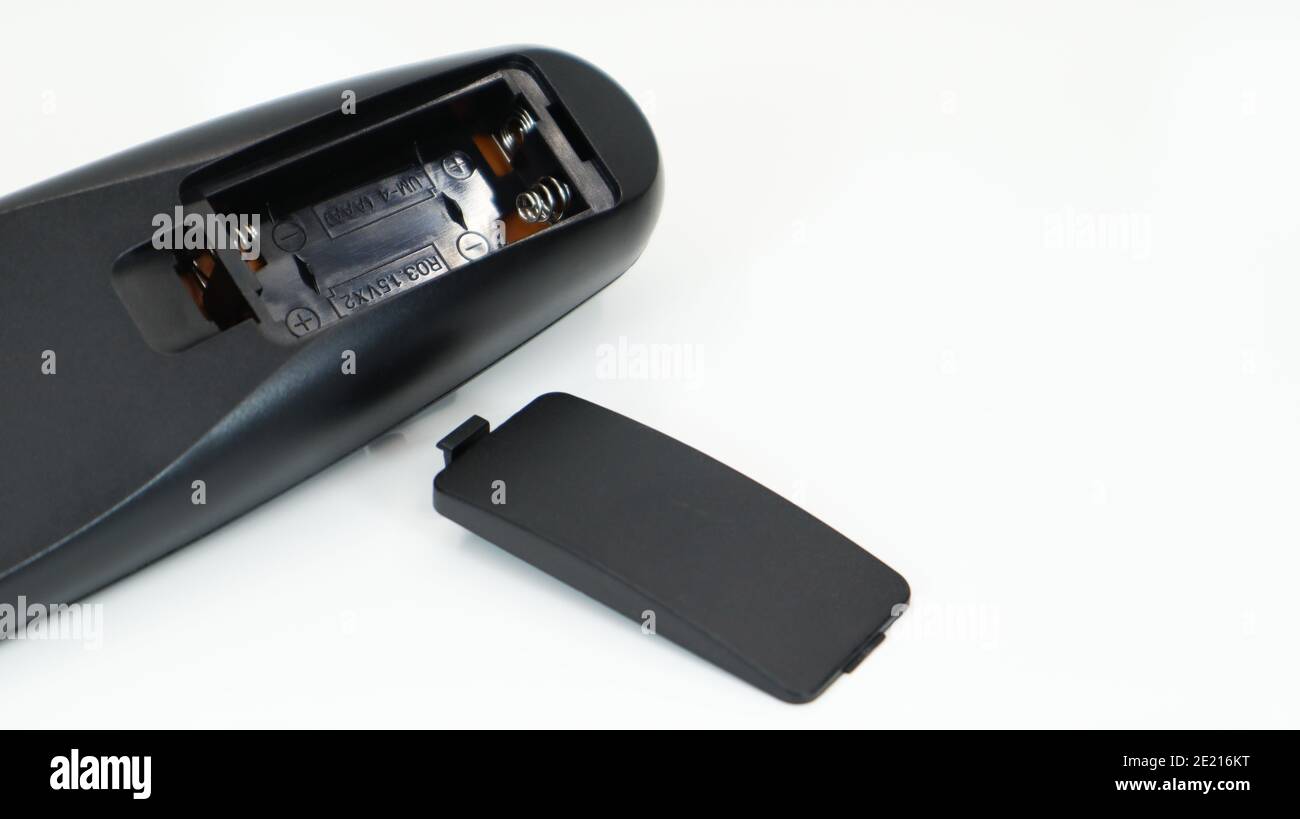Black TV remote control with AAA alkaline batteries on a white ...