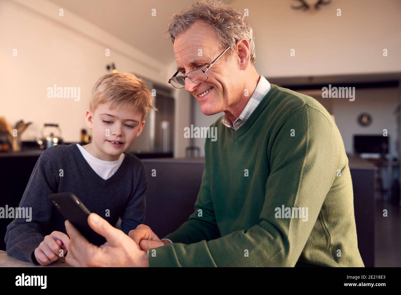 Grandson Showing Grandfather How To Solve Problem And Use Mobile Phone ...