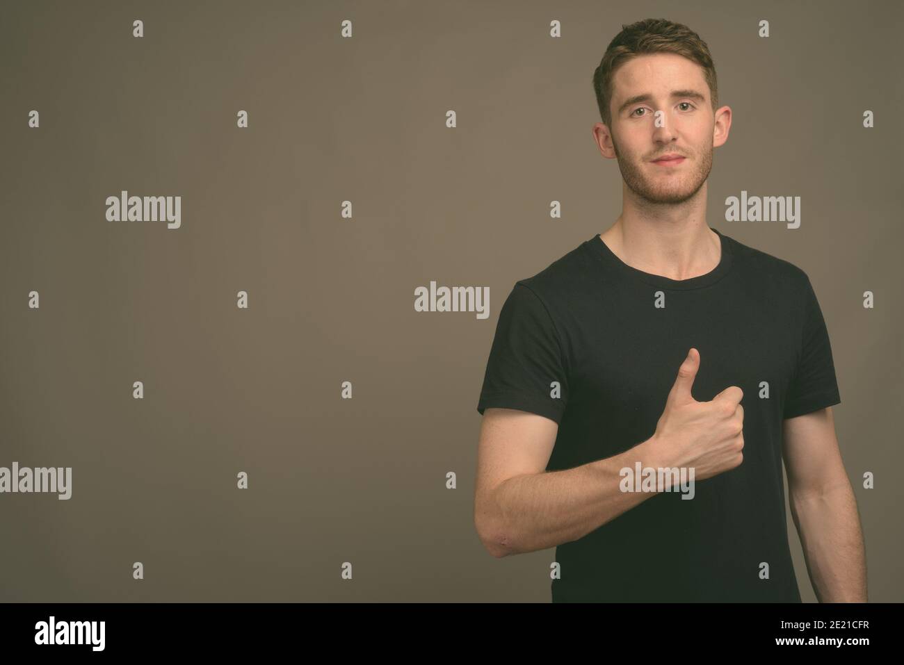 Young handsome man against gray background Stock Photo - Alamy