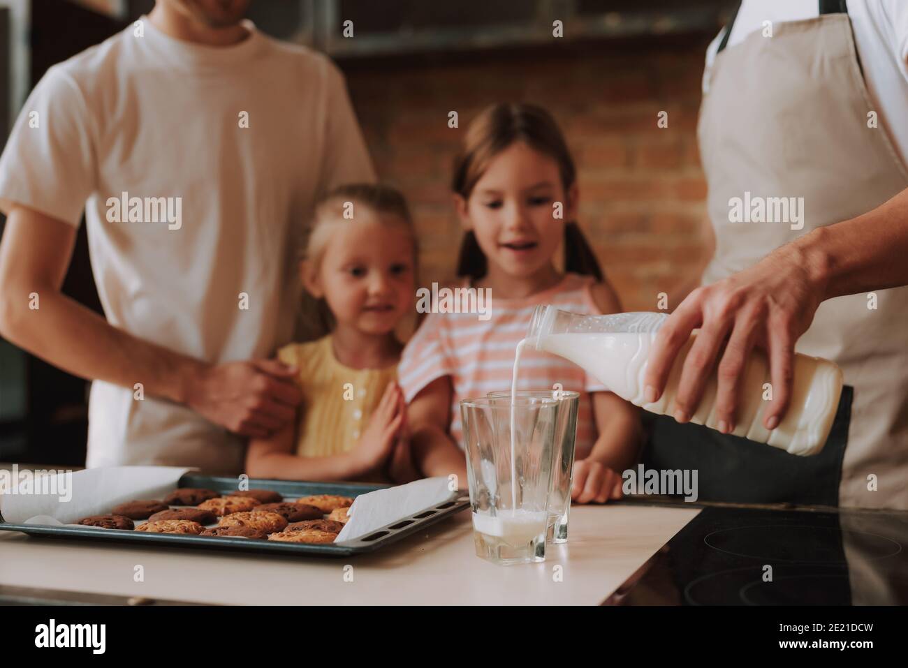 Cropped image of gay couple with their adopted cute daughters cooking ...
