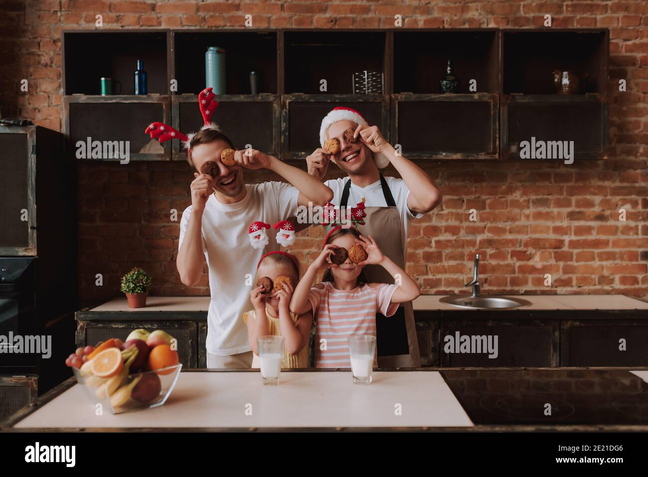 Gay couple with their adopted cute daughters cooking on kitchen. Lgbt ...