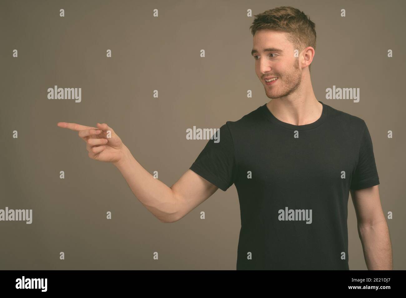 Young handsome man against gray background Stock Photo - Alamy