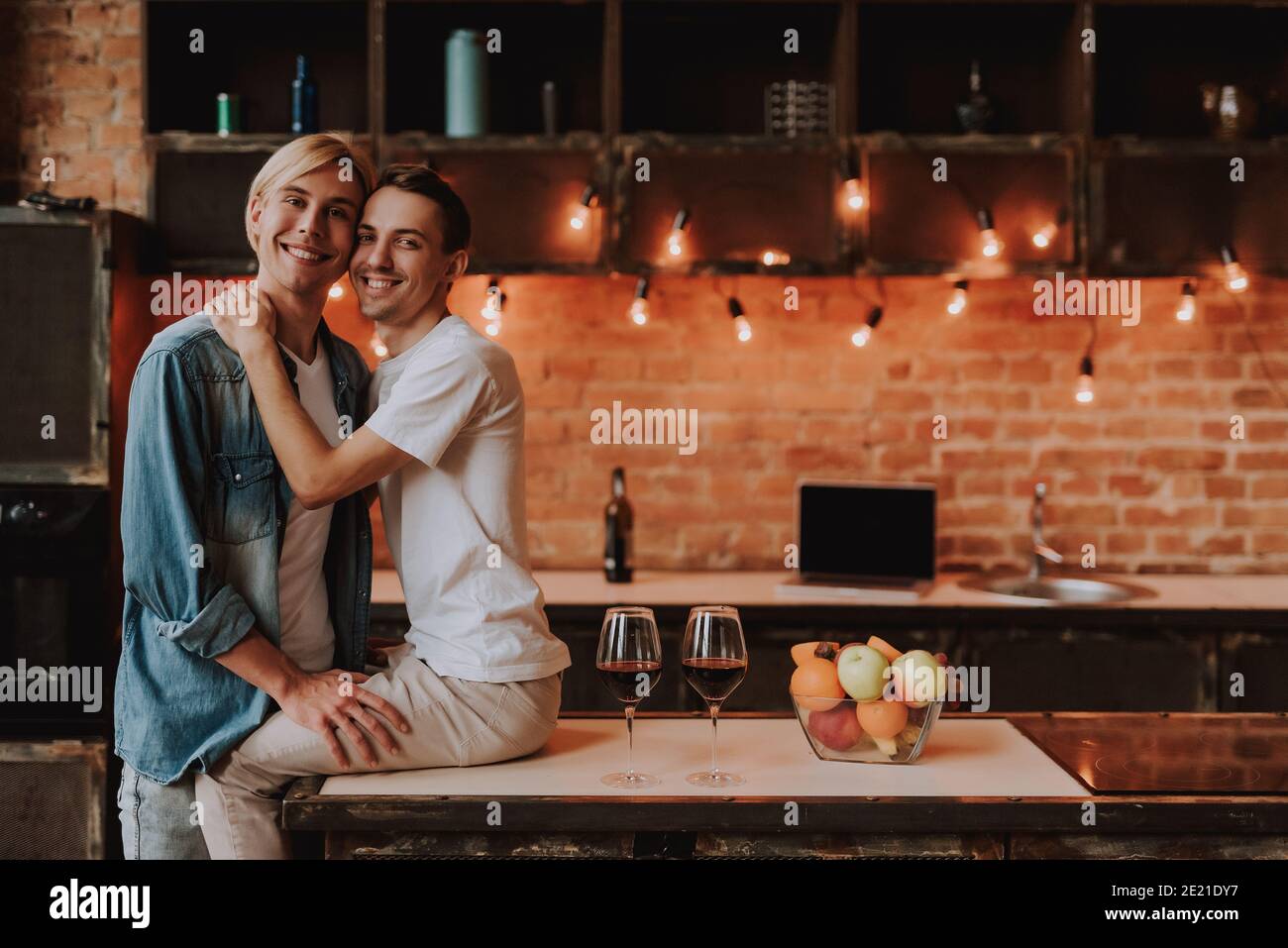 Loving gay couple at home. Two handsome men hugging and kissing on ...