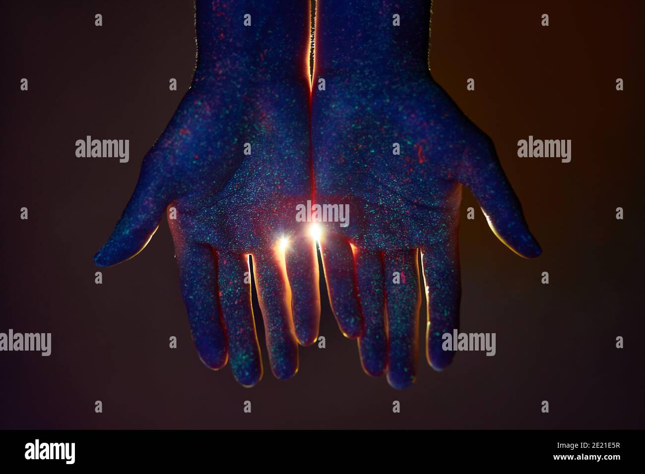 Beauty hands in ultraviolet light in drops of colored paint. Light ...