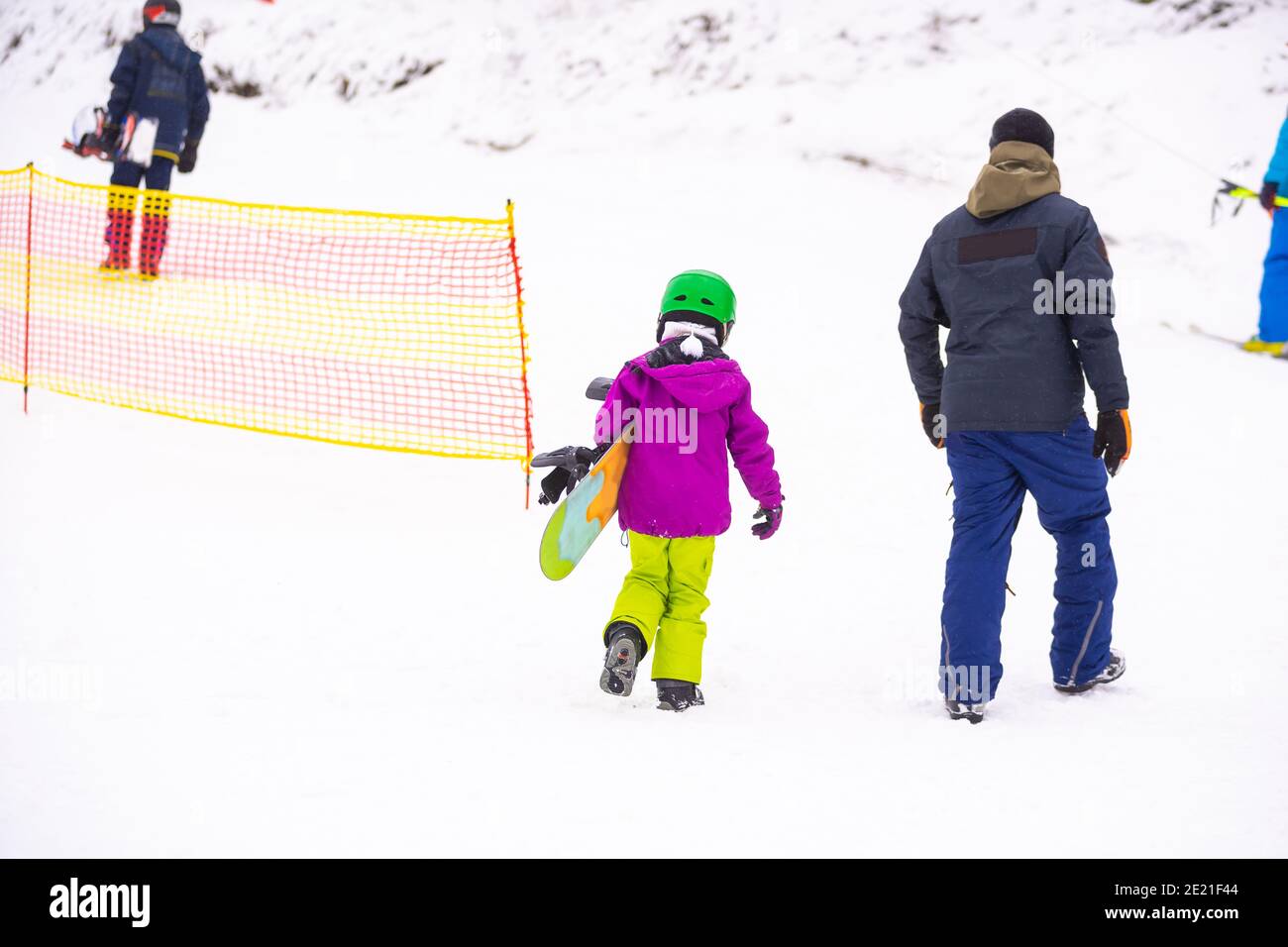 Instructors teach a child on a snow slope to snowboard Stock Photo - Alamy