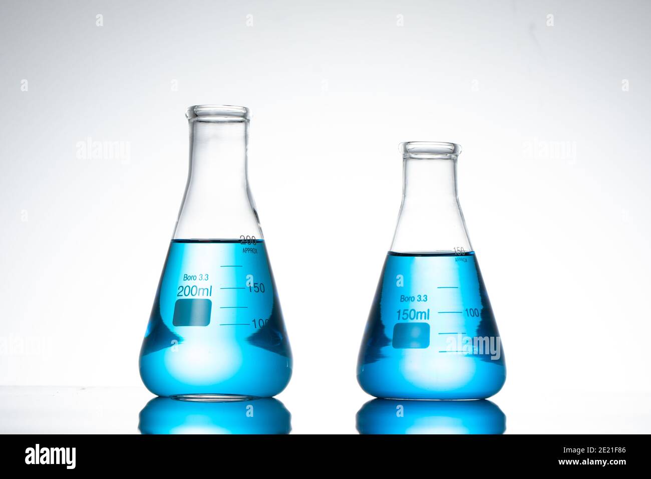 Two conical flasks with blue liquid on a white background Stock Photo ...