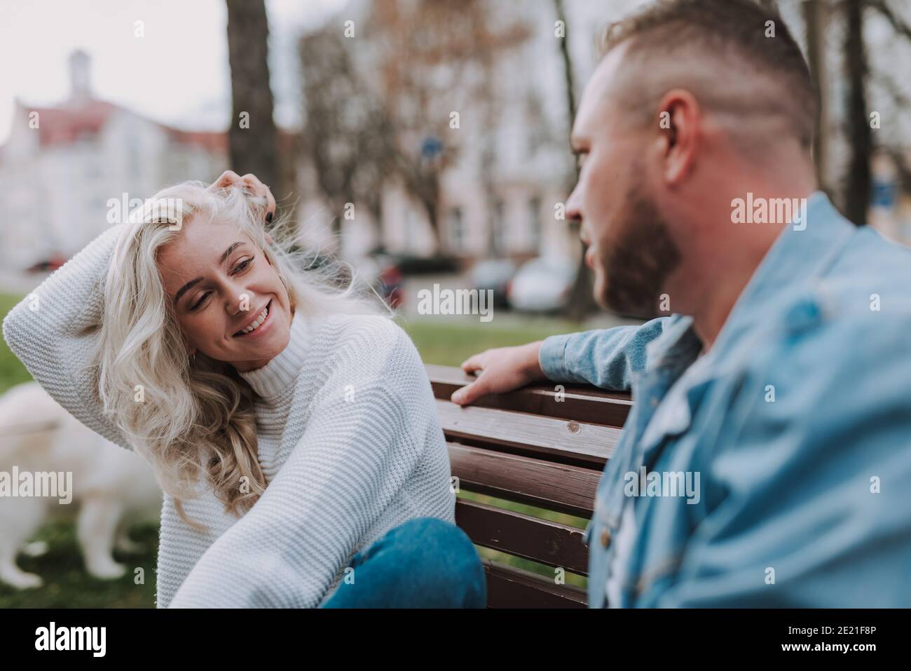 Happy pretty smiling female is flirting with her male while sitting on ...