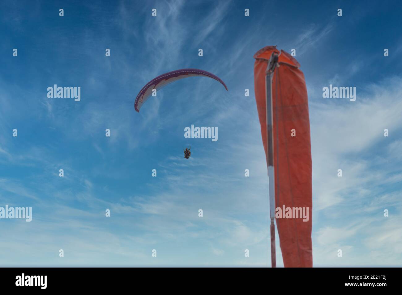 Low angle shot of a paraglider flies in the sky against the background ...