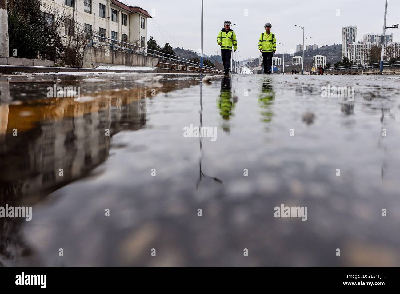 Panzhou. 11th Jan, 2021. Traffic policemen check the surface of the ...