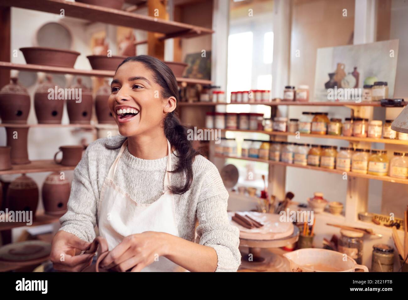 Female Potter Fitting Clay Handles To Mugs In Ceramics Studio Stock ...