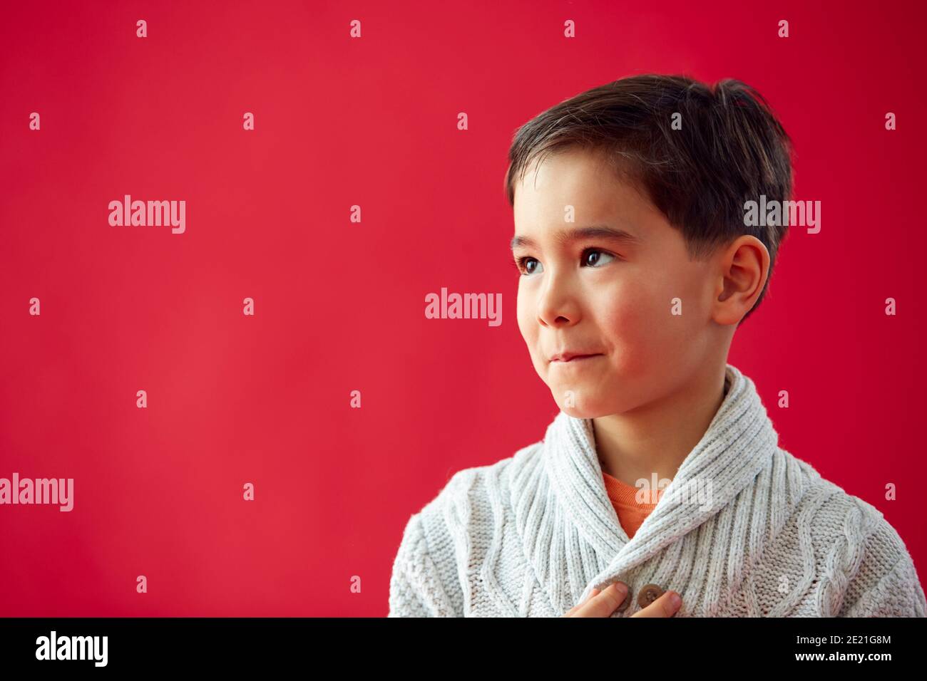 Profile Of Smiling Young Boy Against Red Studio Background Stock Photo ...