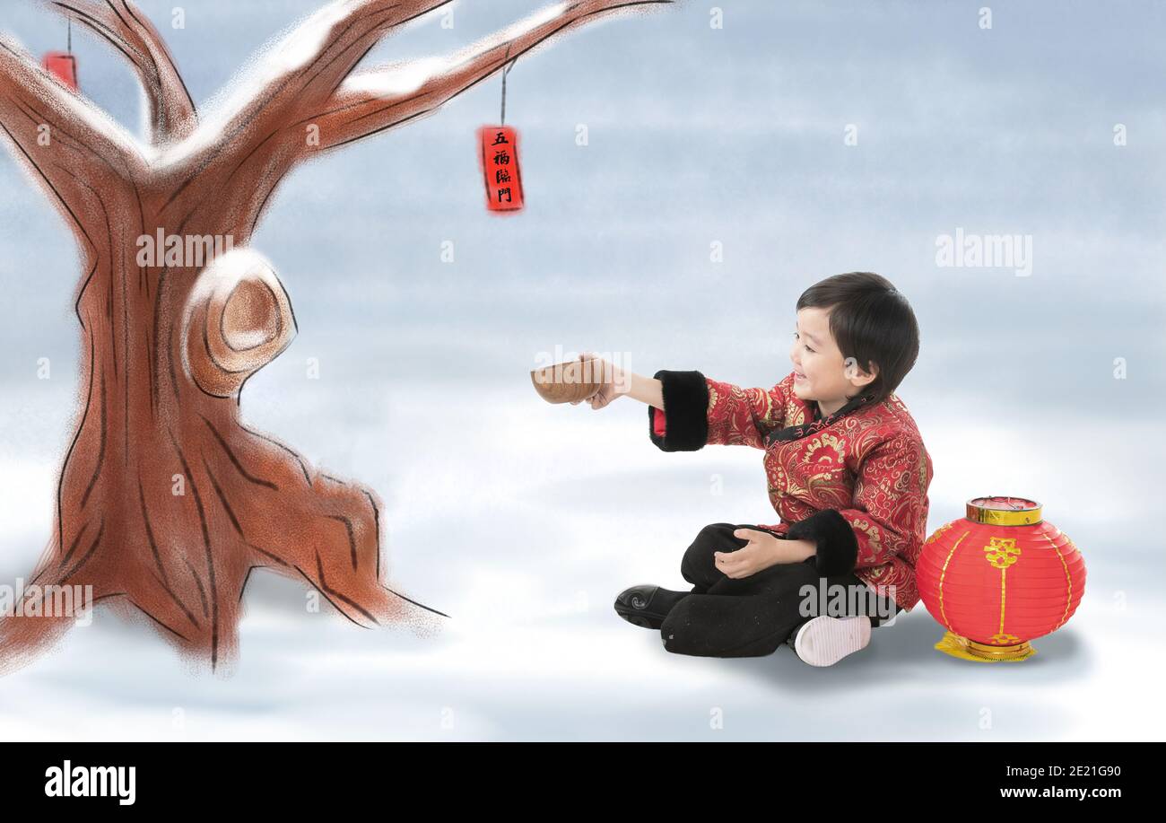 A happy little boy sitting under the tree Stock Photo - Alamy