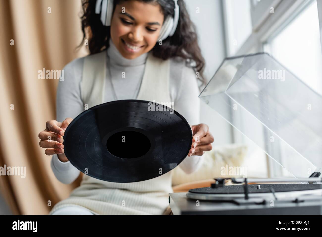 happy african american woman in wireless headphones holding vinyl disc ...