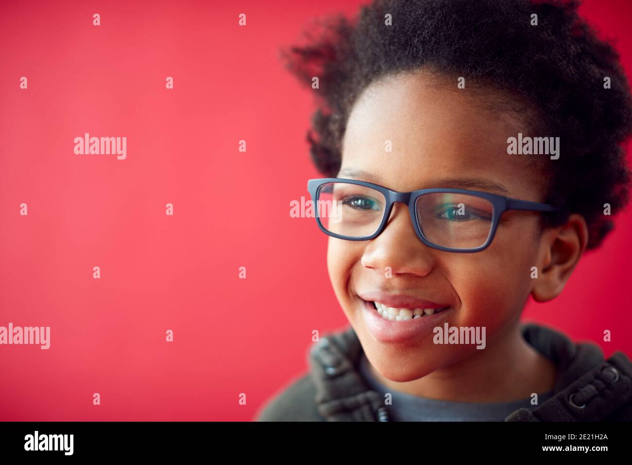 Portrait Of Smiling Young Boy Wearing Glasses Against Red Studio ...