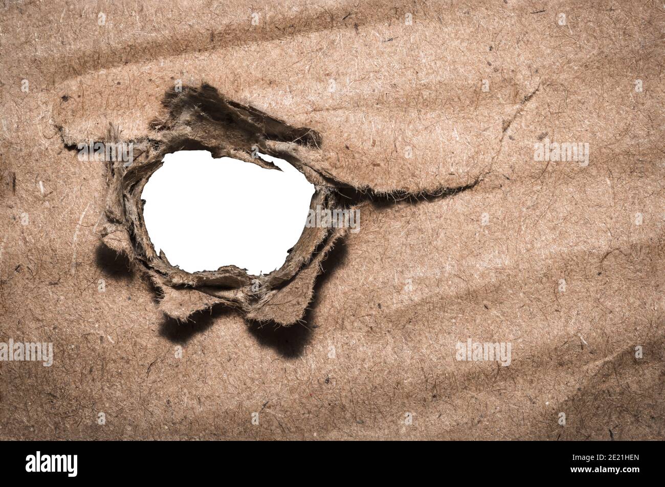 Closeup of paper hole with torn edges on white background, space for ...