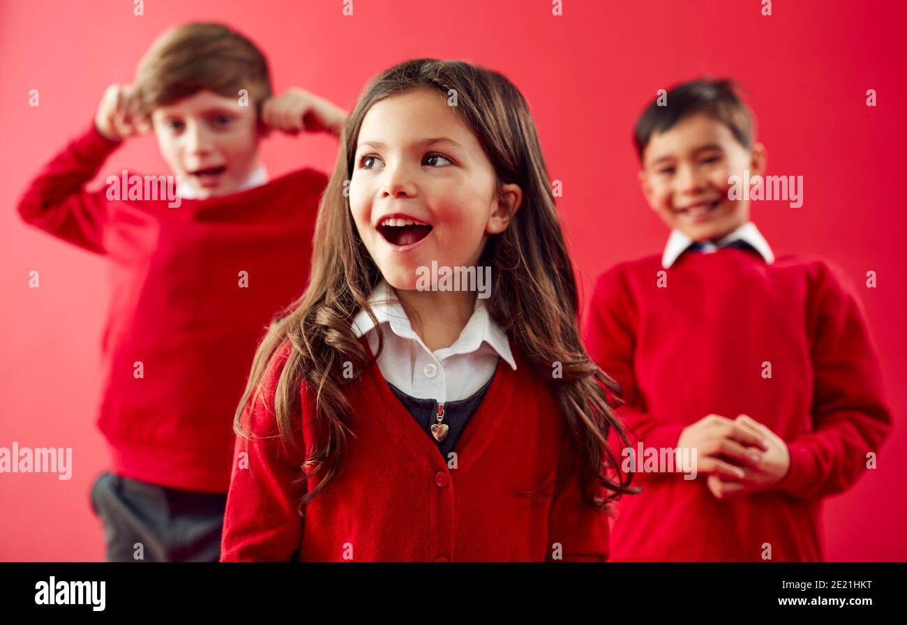Group Of Excited Elementary School Pupils Wearing Uniform Having Fun ...