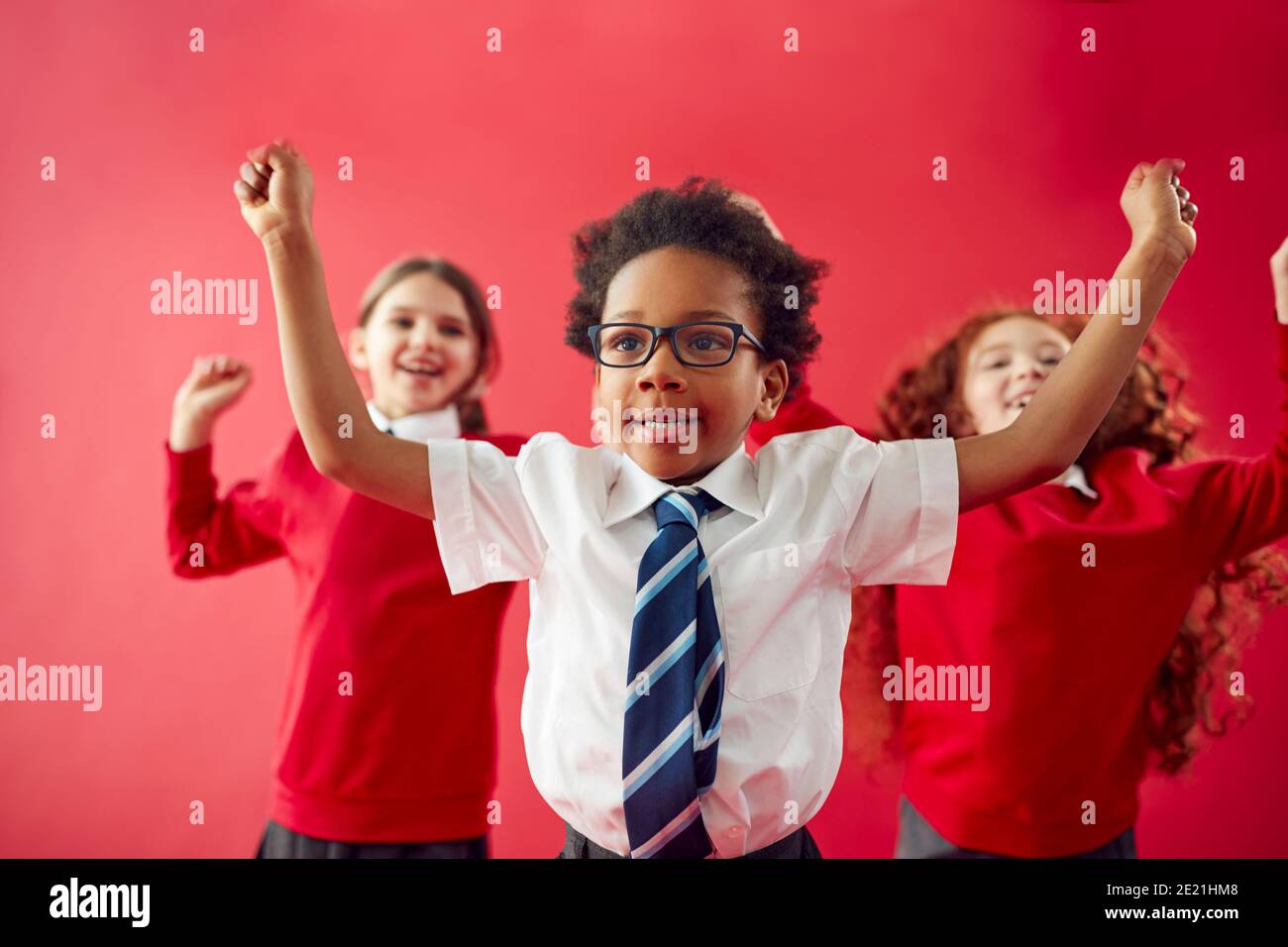 Group Of Excited Elementary School Pupils Wearing Uniform Having Fun ...