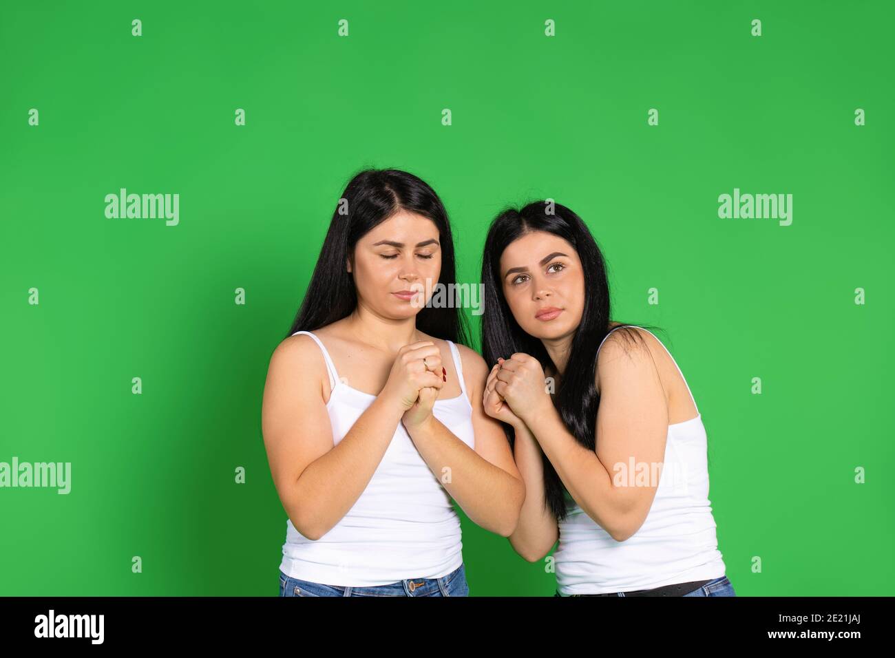 Emotion concept on green background. The twins with a sad face froze ...